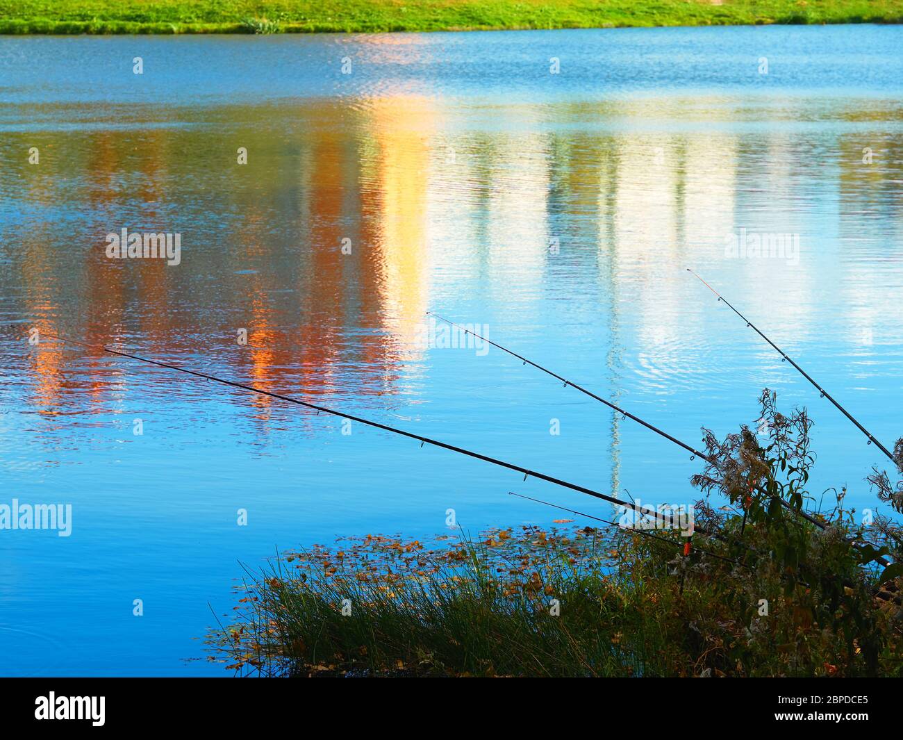 Multiple fishing rods with stunning water reflections background Stock ...