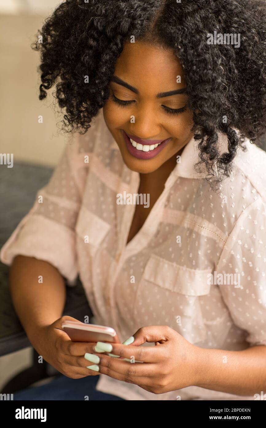 Happy African American woman texting and talking Stock Photo - Alamy