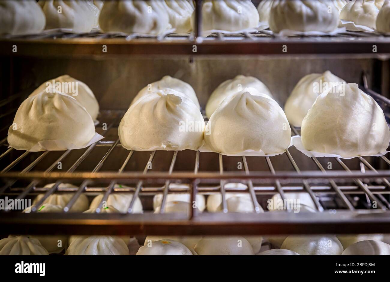 Freshly baked traditional Chinese bao buns on a rack on display at a ...