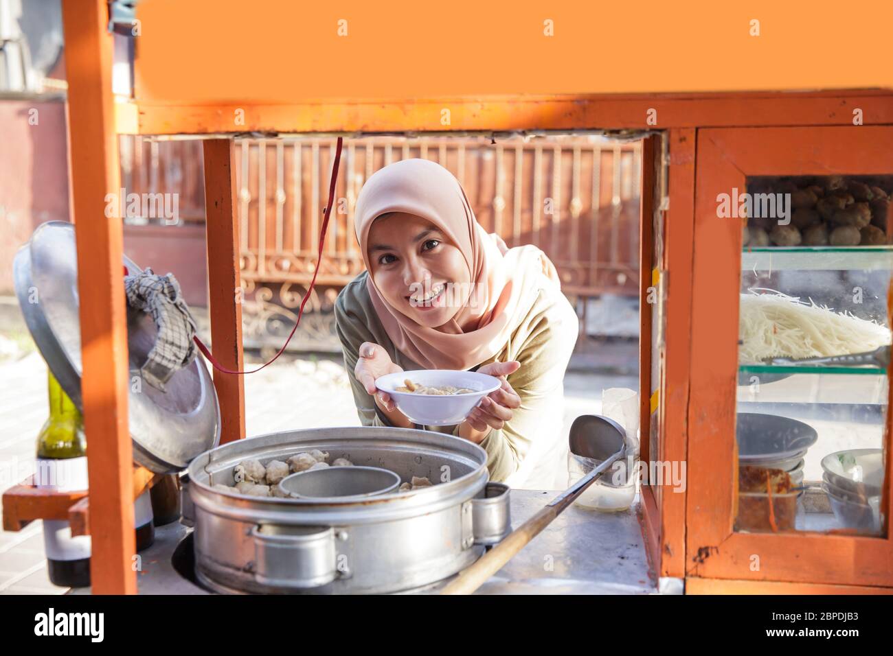beautiful asian woman muslim customer buying bakso Stock Photo - Alamy