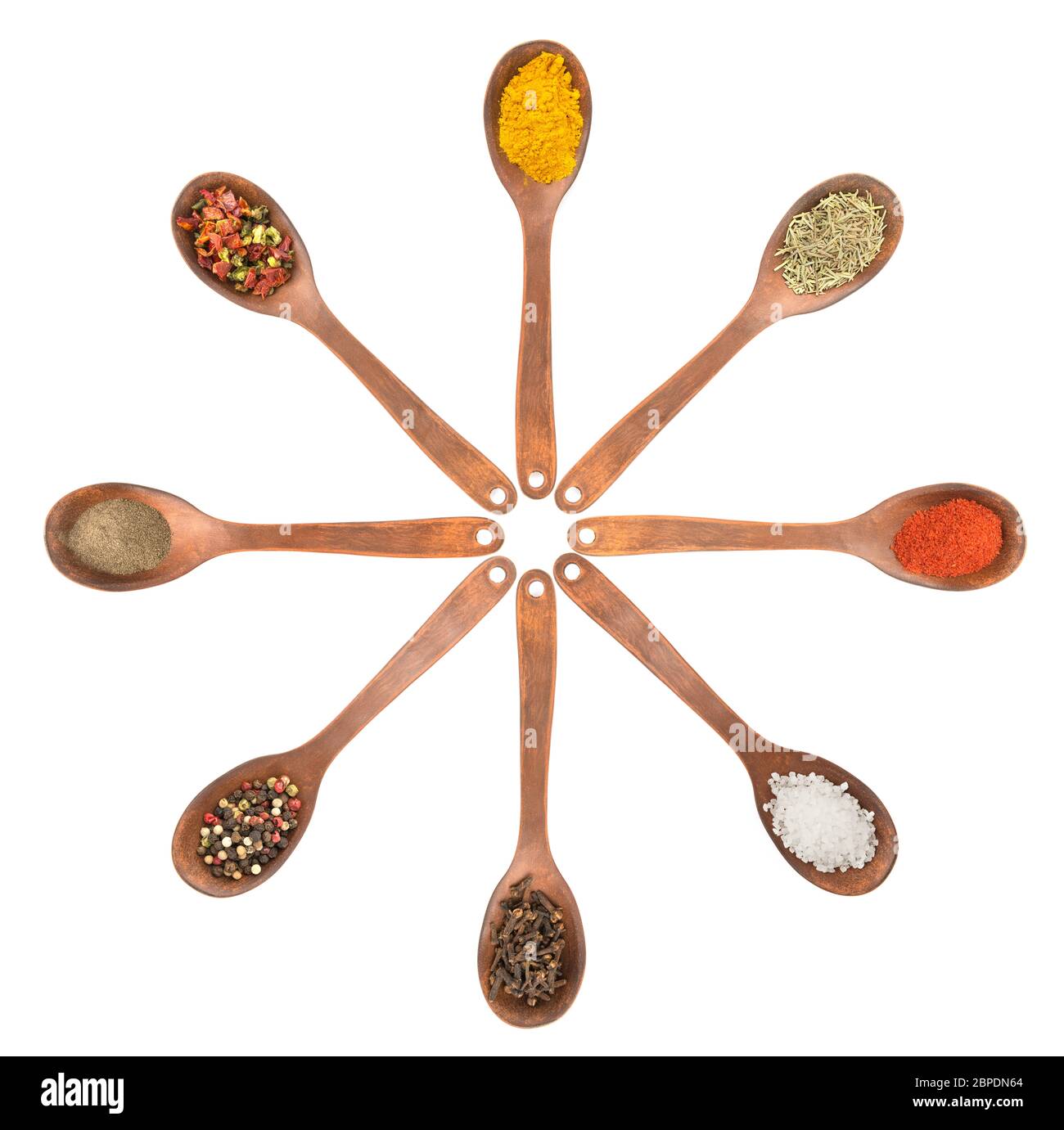Collection of ceramic spoons with different spices isolated on white ...