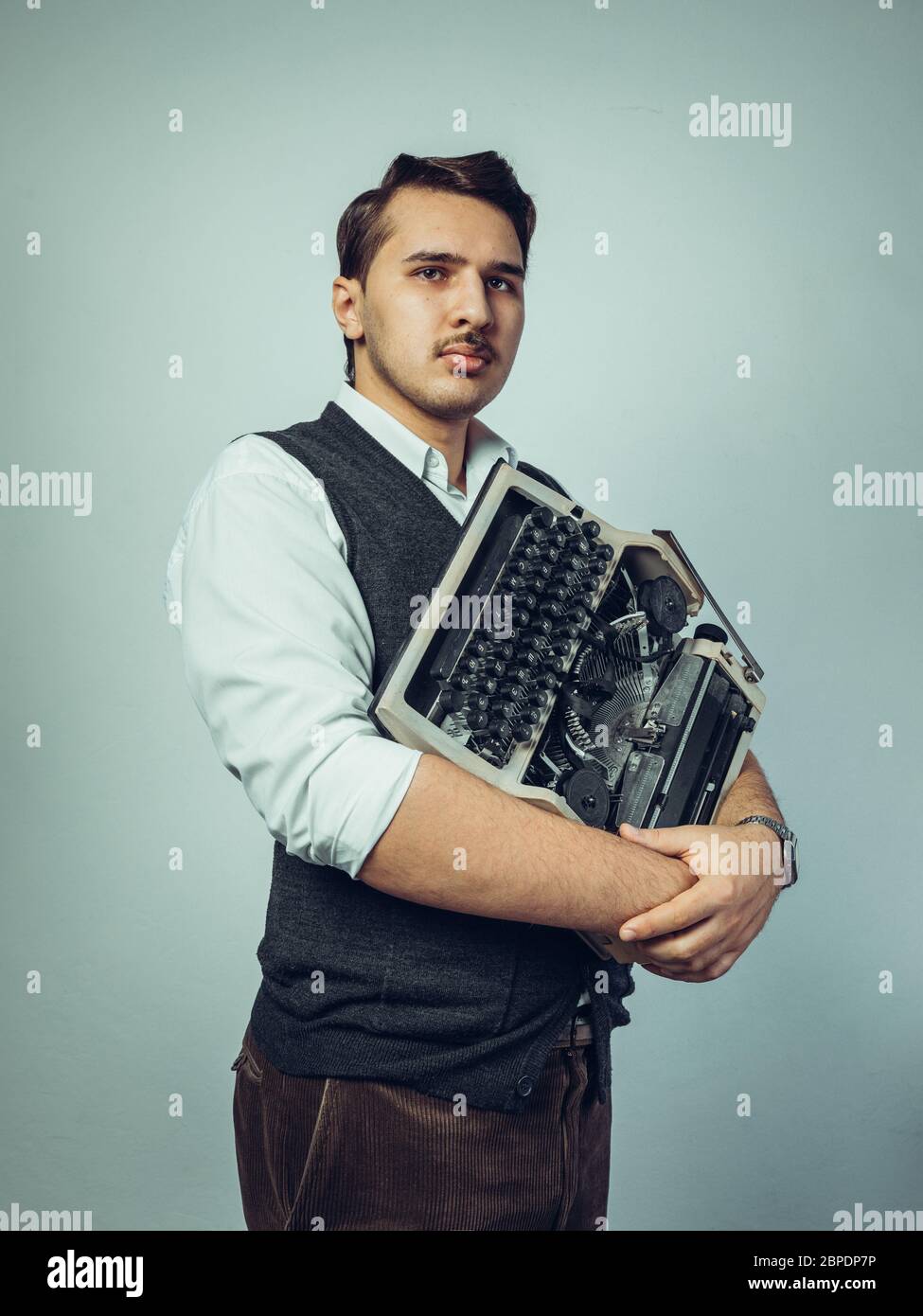 Portrait Of Man Holding Typewriter Stock Photo - Alamy
