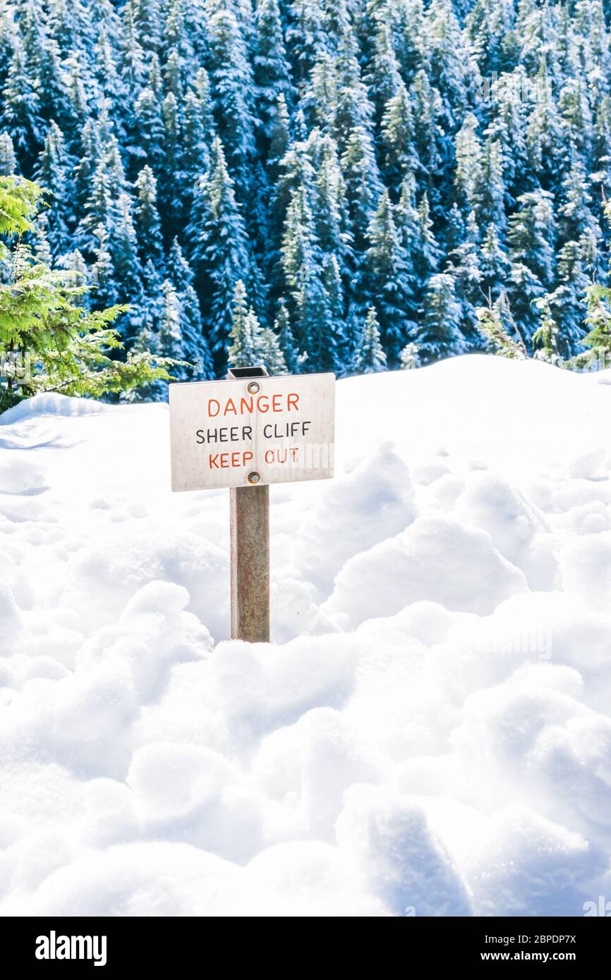 danger sheer cliff keep off sign on the edge of land cover with snow ...
