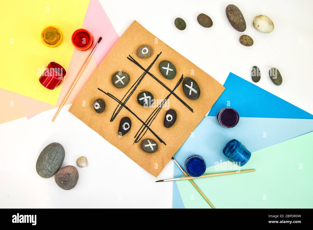 top view of tic tac toe game with stones marked with naughts and ...