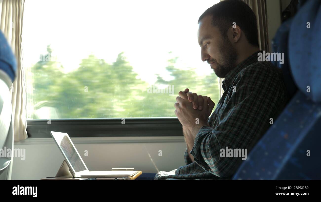 Excited man checking work on a tablet in the train being satisfi Stock ...