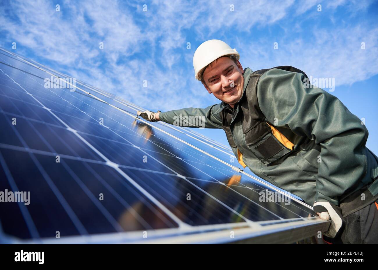 Cheerful male worker smiling to the camera while installing blue ...