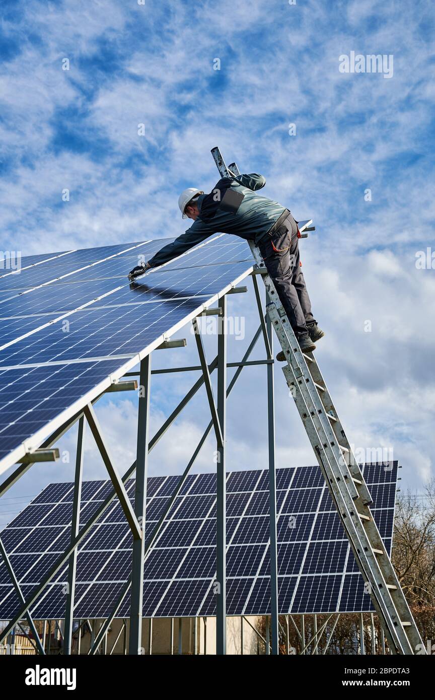 Vertical snapshot of working process in a solar field. Technician in ...