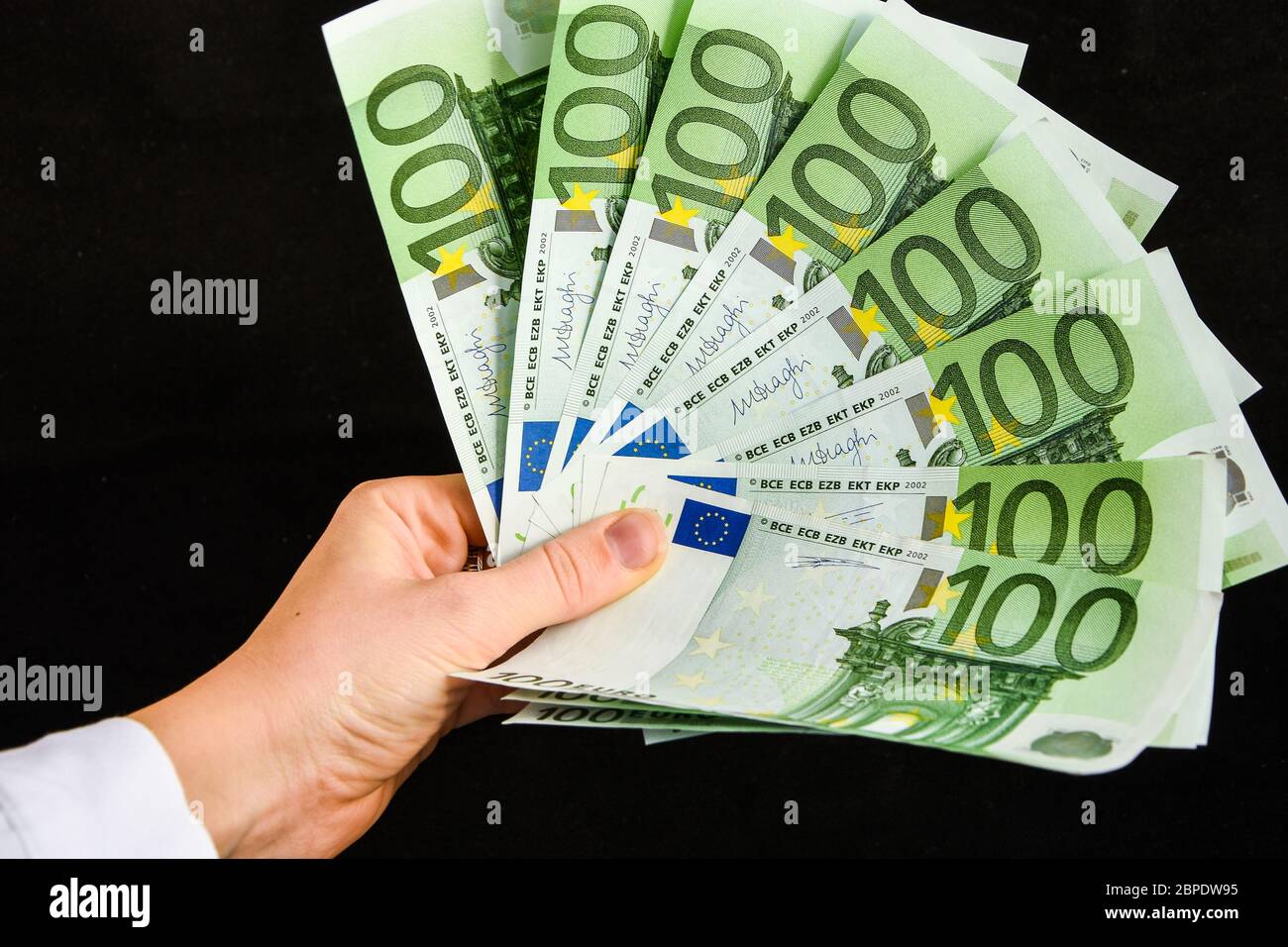 hand with euro isolated on black background, Hand holding euros ...