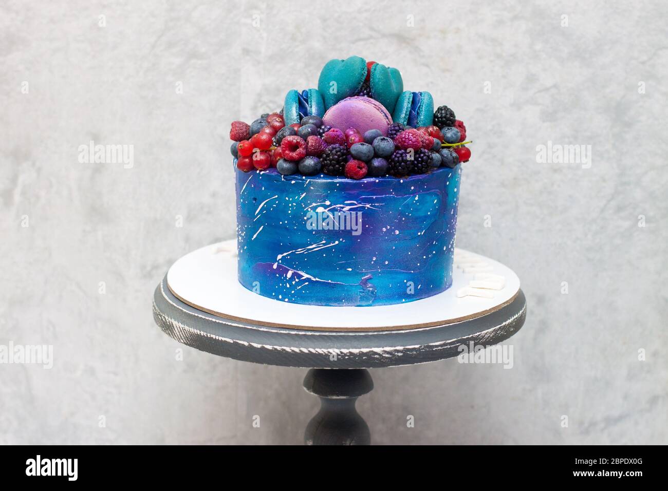 Space blue birthday cake on rustic cakestand decorated with fresh ...