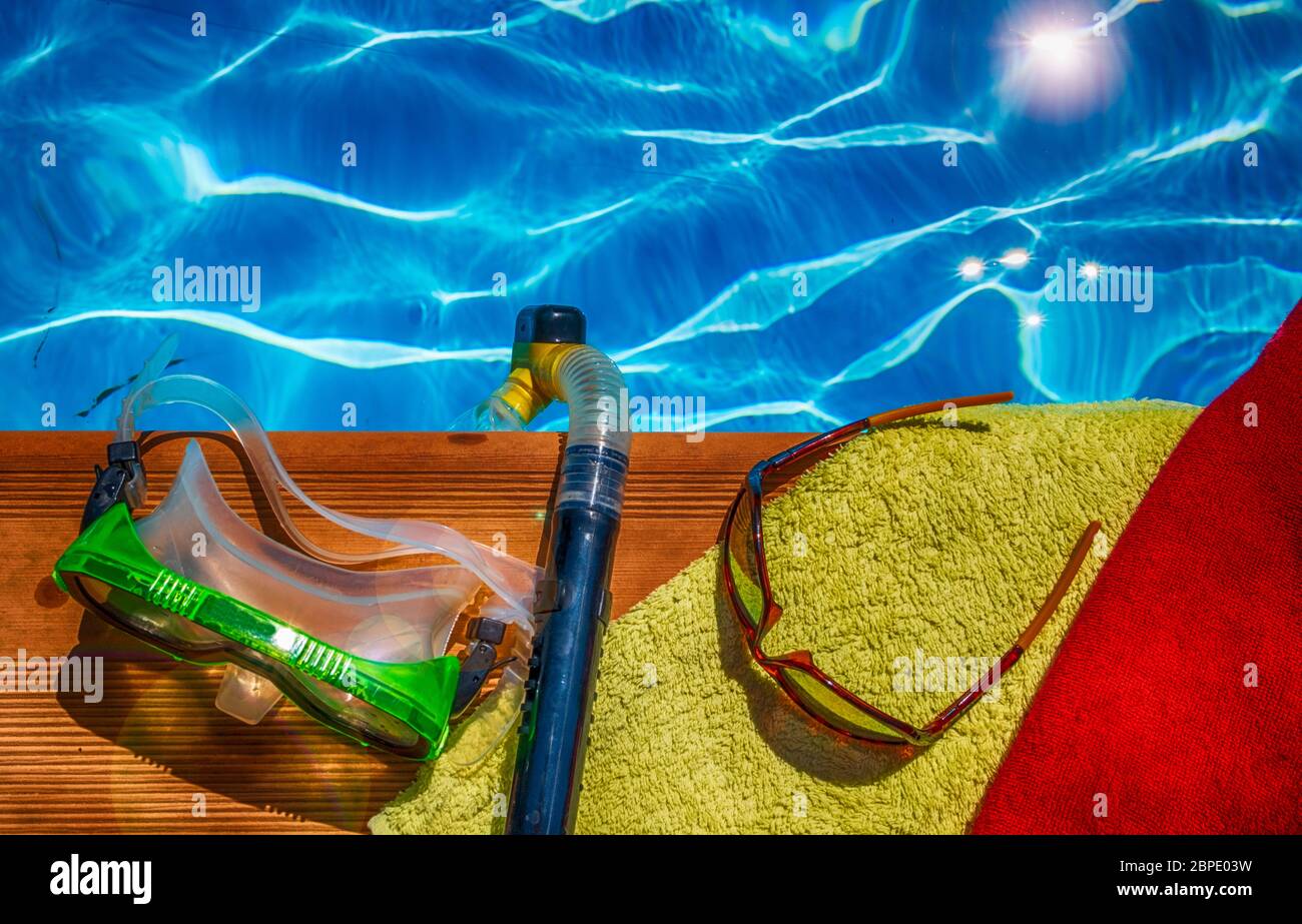 Sun flare in sunlit swimming pool with snorkel mask, sunglasses and ...