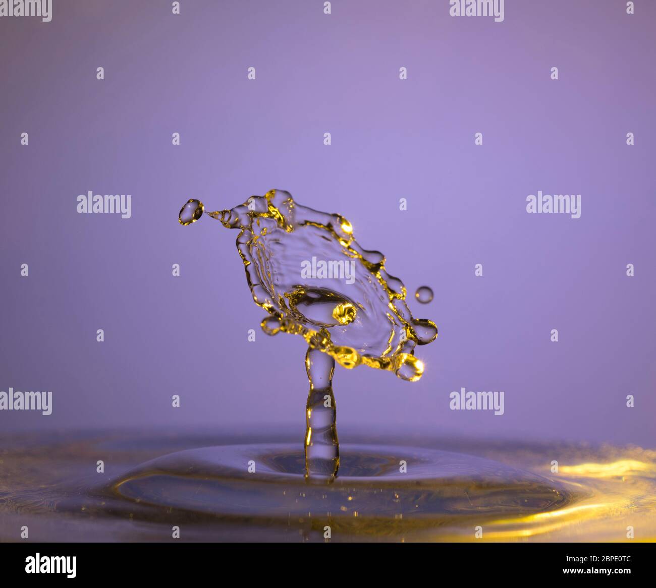 Falling water droplet against coloured background forming shape ...