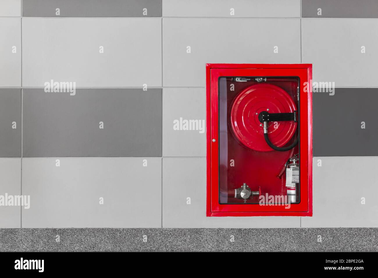 Hydrant with water hoses and fire extinguish equipment on the wall in ...
