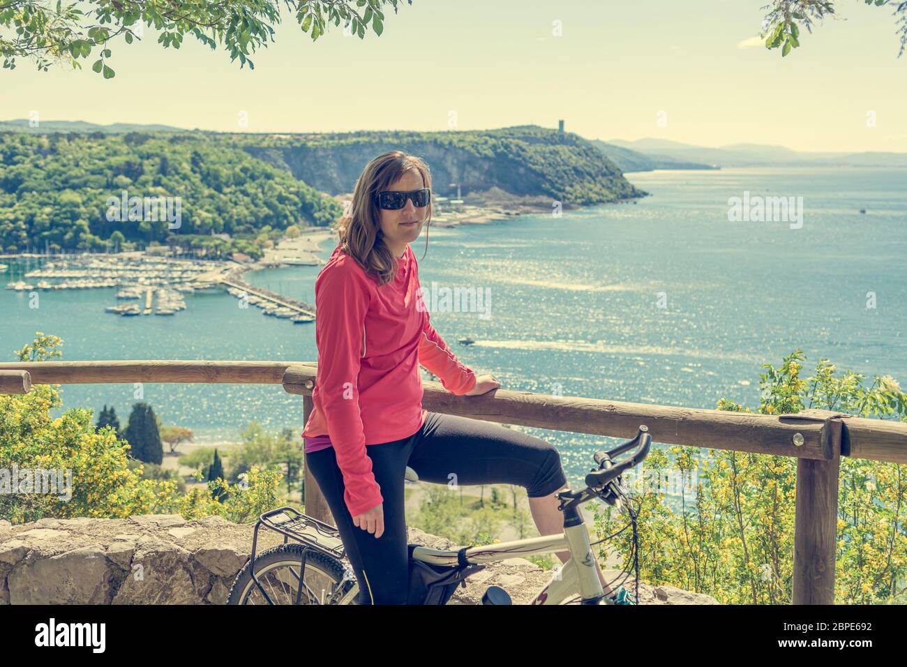 Active female cyclist taking a rest on her bike and enjoying amazing ...