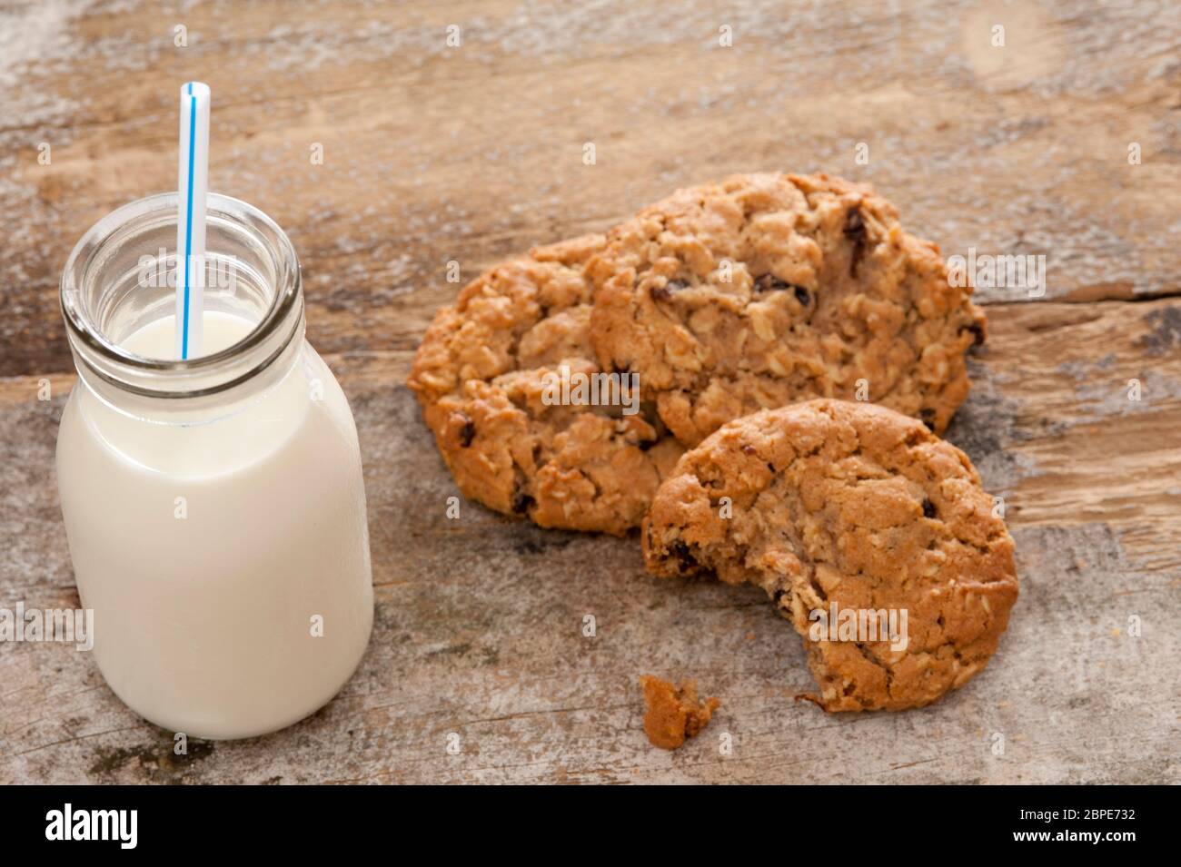 Small glass bottle of fresh creamy farm milk with a straw alongside ...