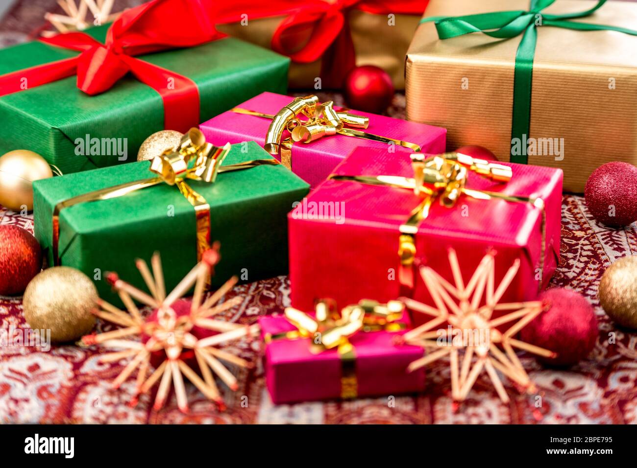 Christmas gifts wrapped in red, green and gold with plain-colored bows ...