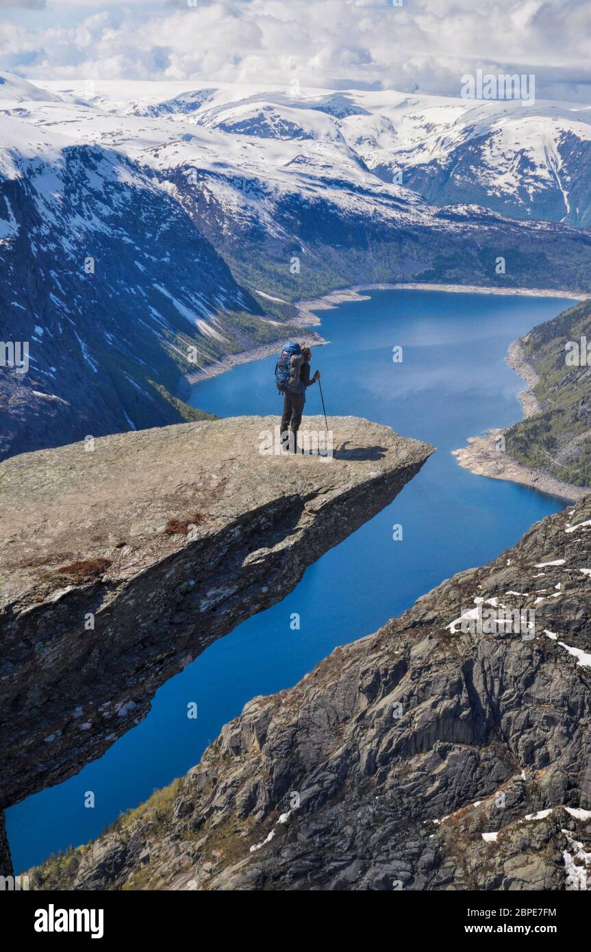 Hiker peering over the edge of Trolltunga rock, Norway Stock Photo - Alamy