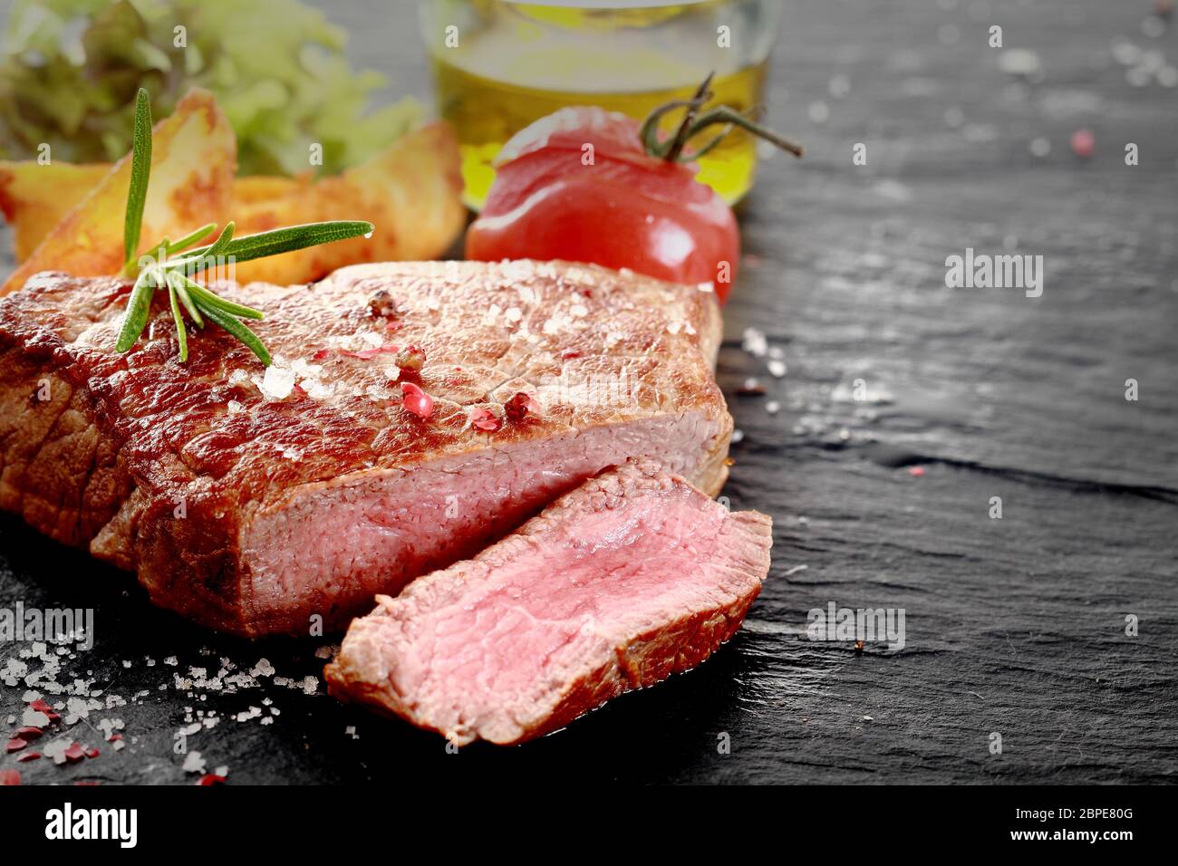 Healthy trimmed lean medallion of grilled rare rump steak sliced ...