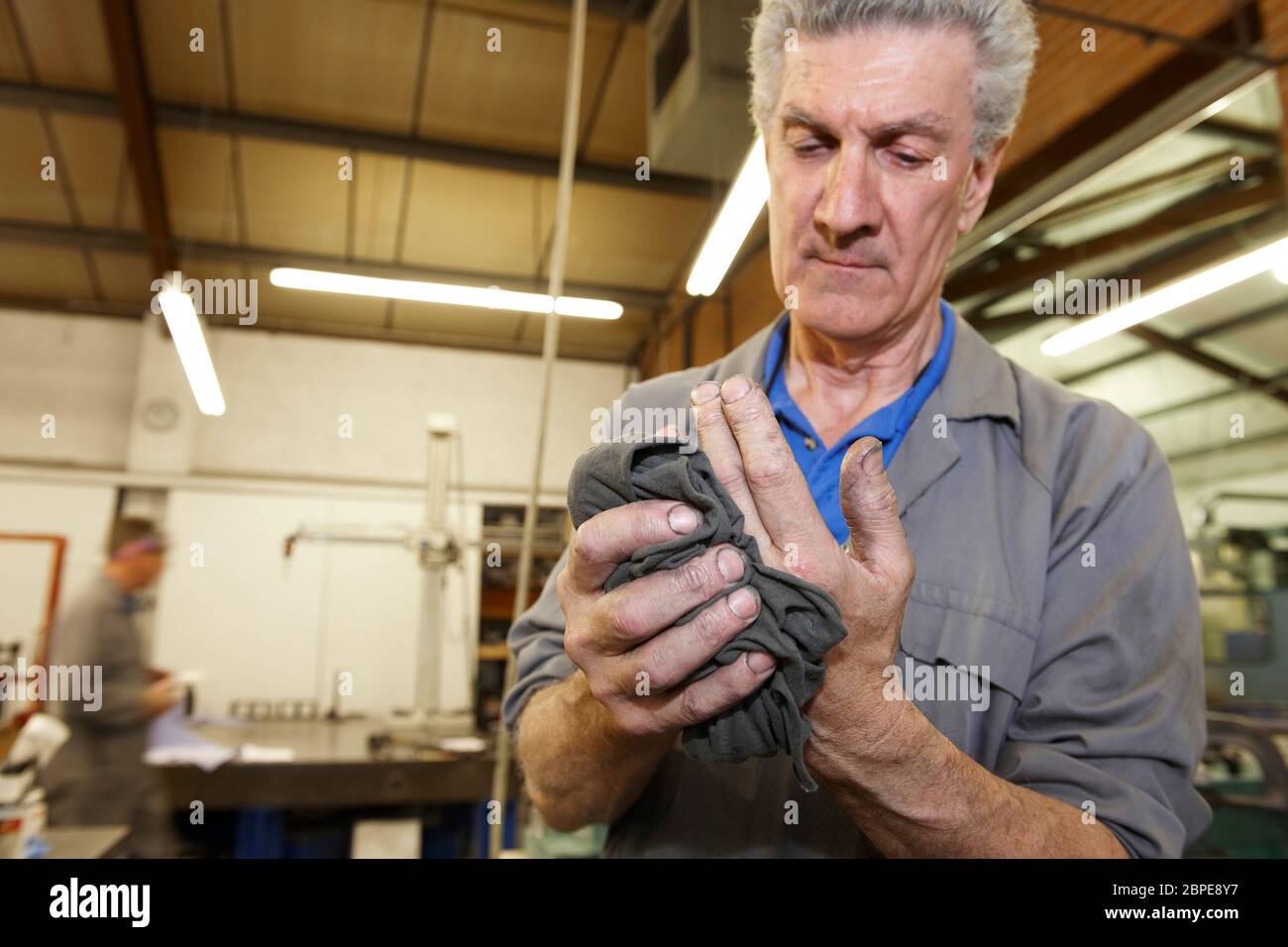 senior worker cleaning his hands with a cloth Stock Photo - Alamy
