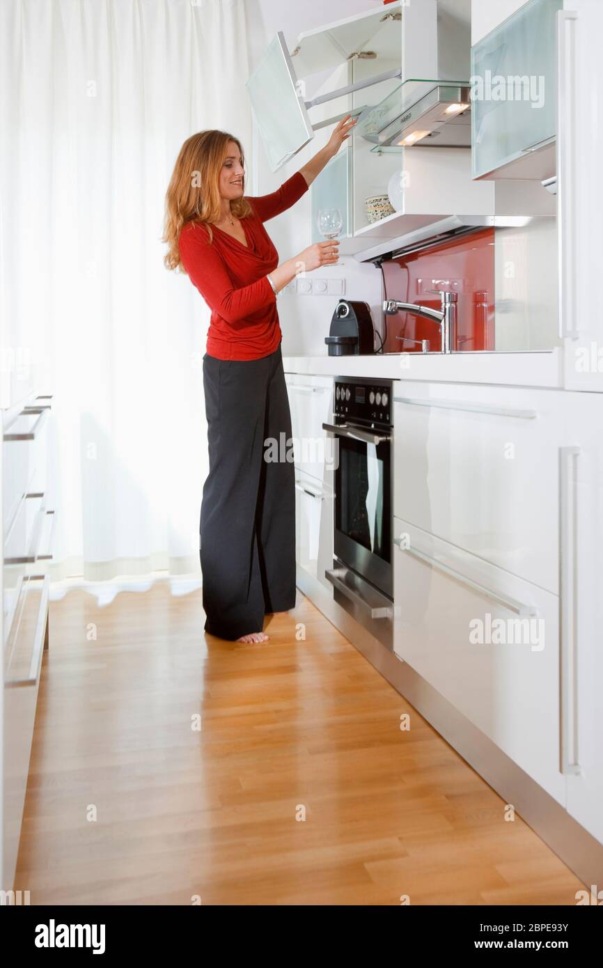 young beautiful woman standing in modern kitchen interior Stock Photo ...