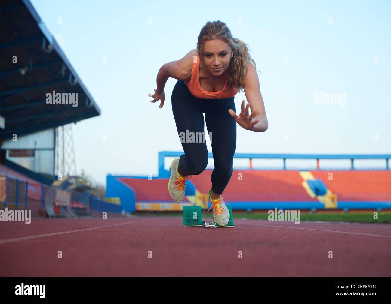 pixelated design of woman sprinter leaving starting blocks on the ...