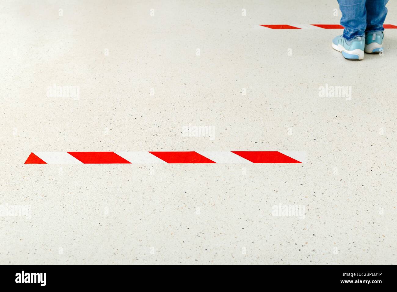 Red stripped line sign for keeping social distance. People standing ...