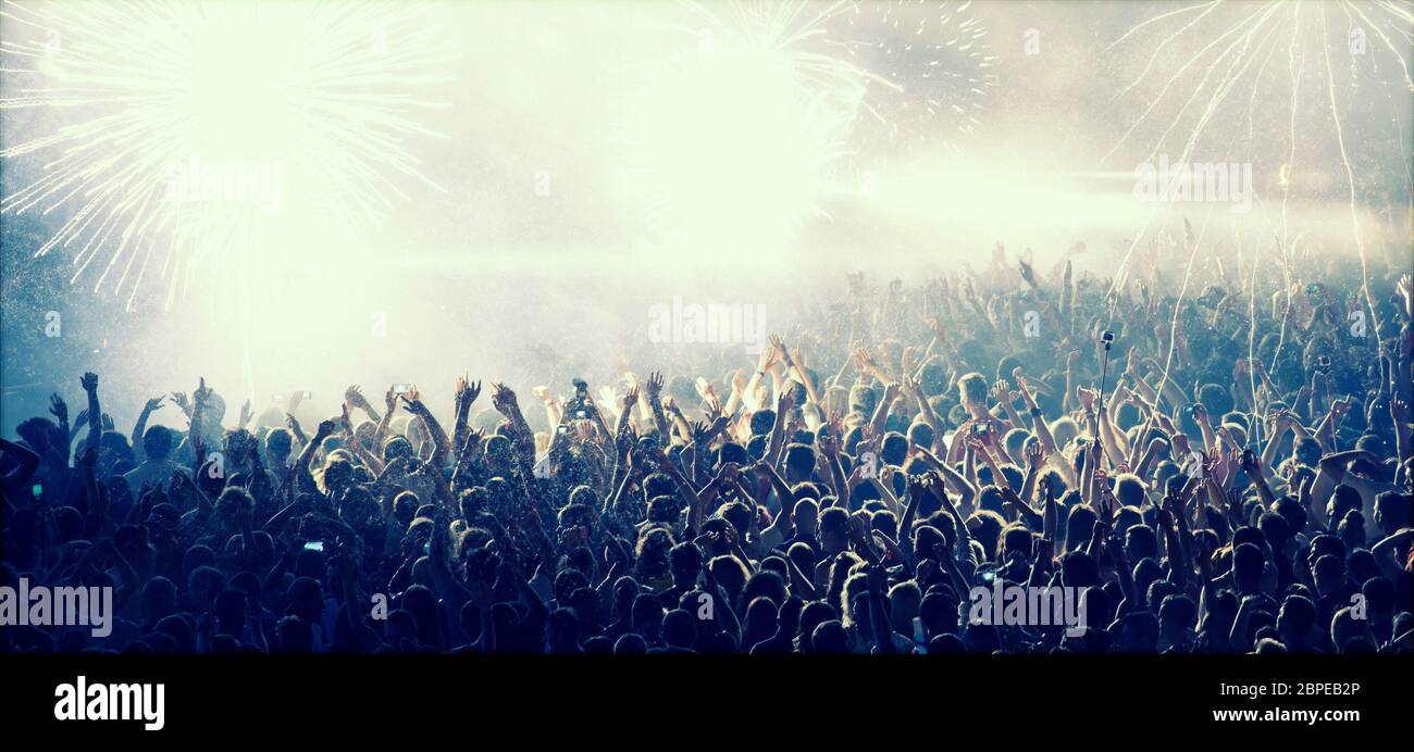 Cheering crowd in front of bright colorful stage lights Stock Photo - Alamy