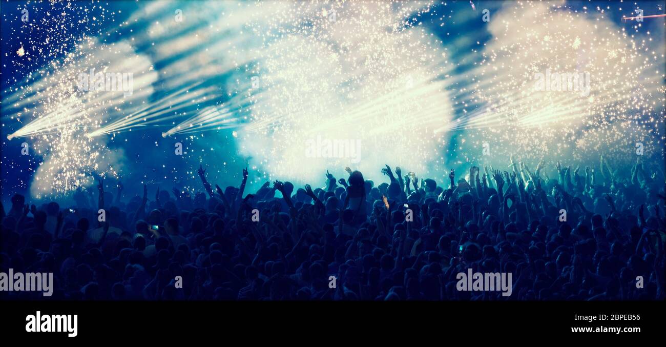 Cheering crowd at concert in front of stage with pyrotechnics Stock ...