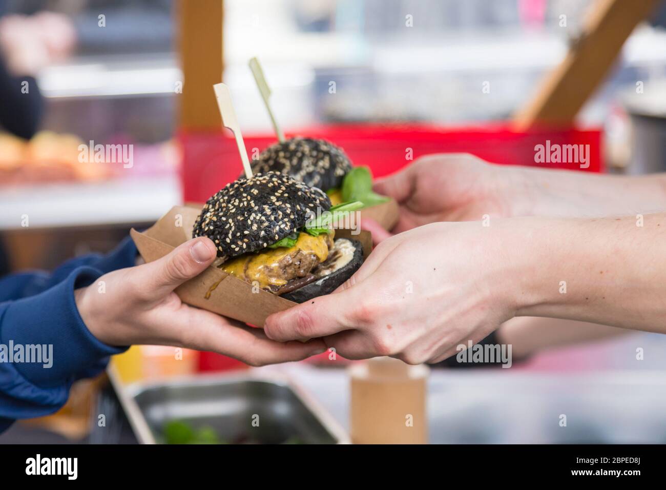 Beef burgers being served on food stall on open kitchen international ...