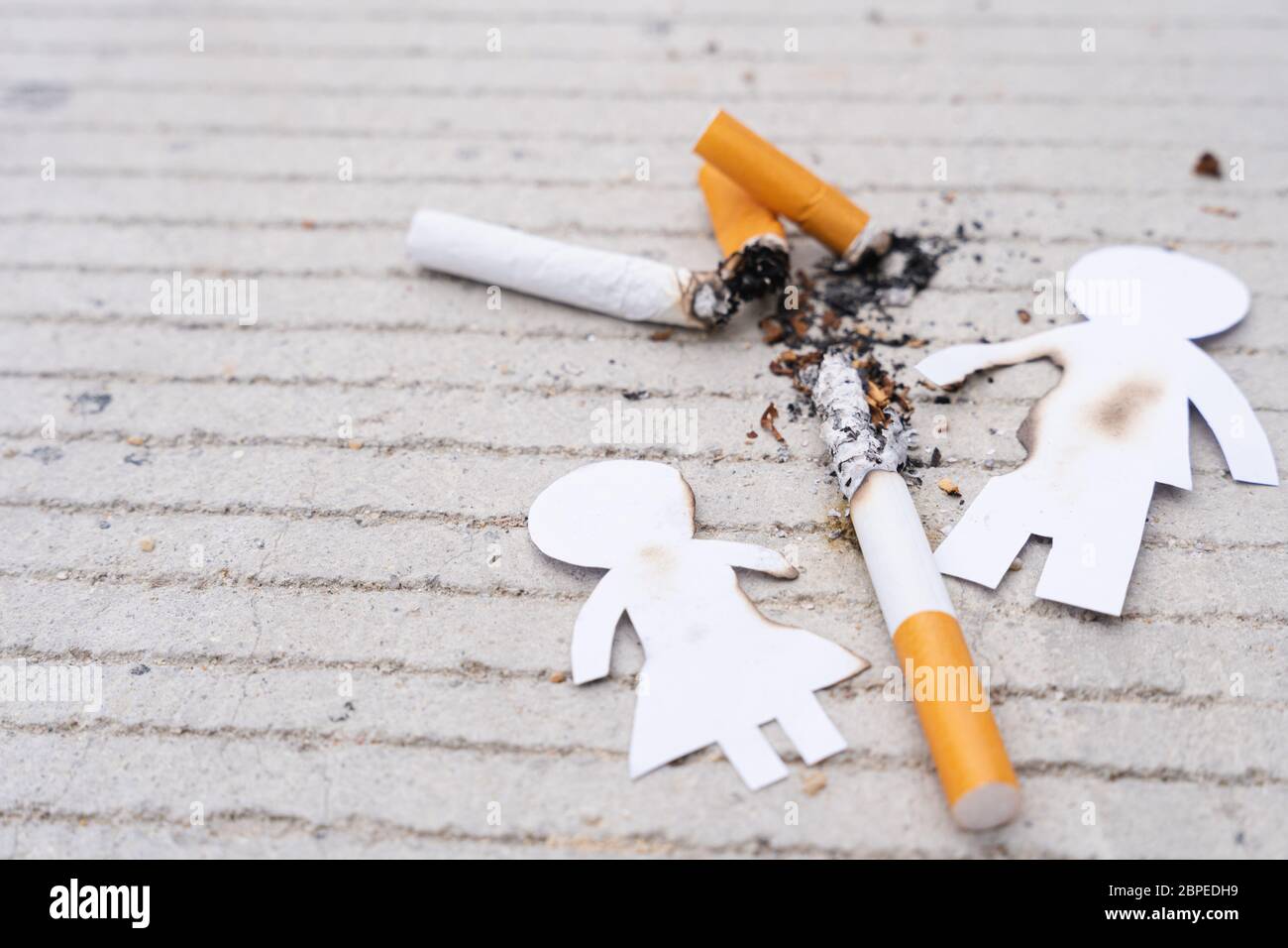 Paper cut of family members destroyed by cigarette. Smoking destroying ...