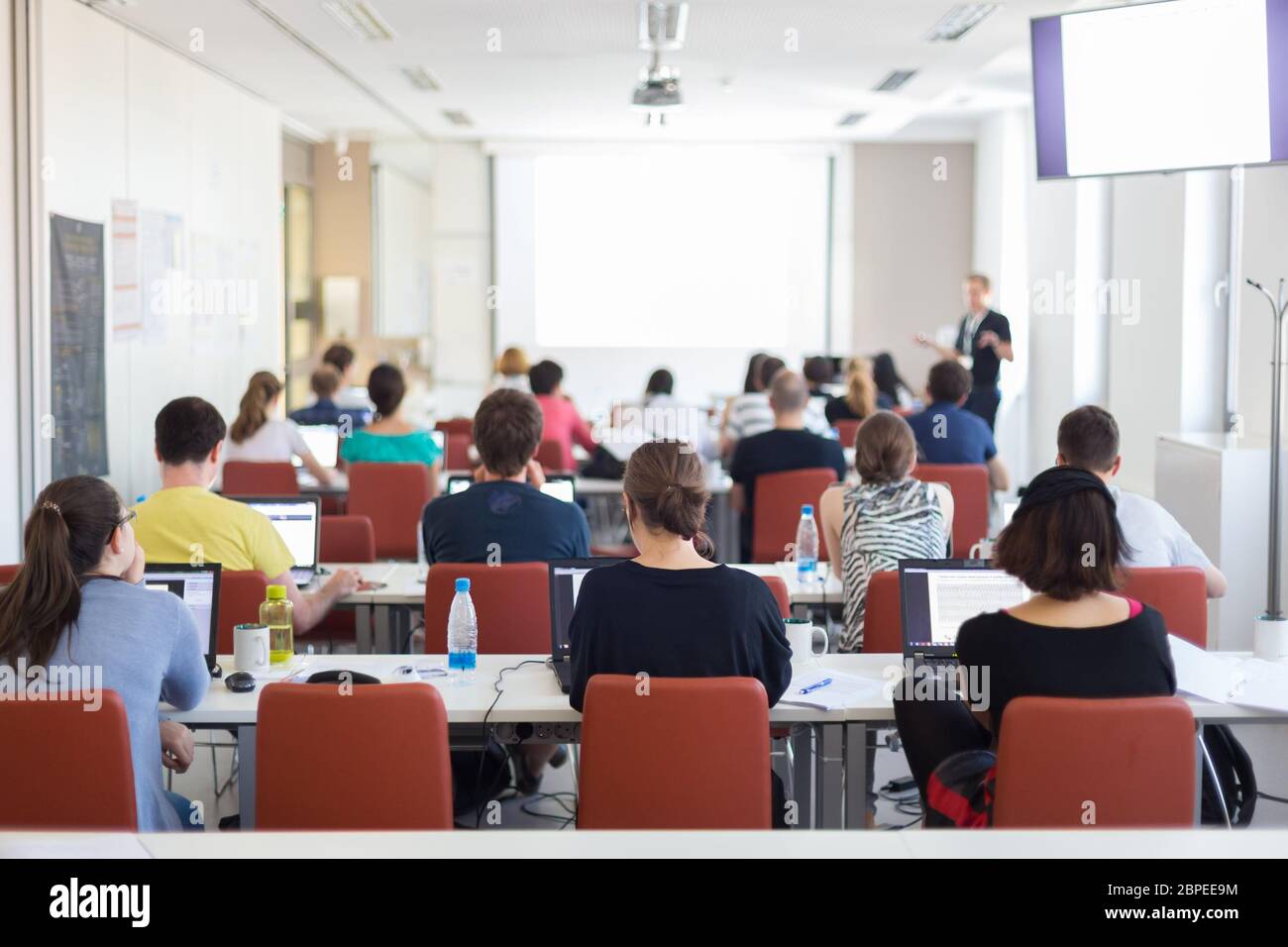 Workshop at university. Rear view of students sitting and listening in ...