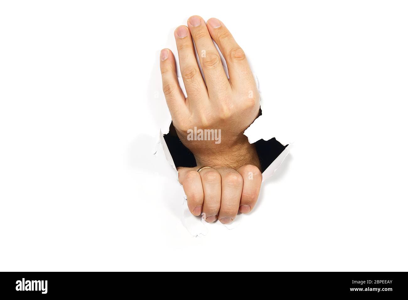 hands opening a hole in white cardboard. Expanding horizons of ...