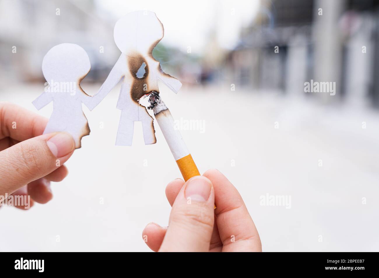 Paper cut of family members destroyed by cigarette. Smoking destroying ...