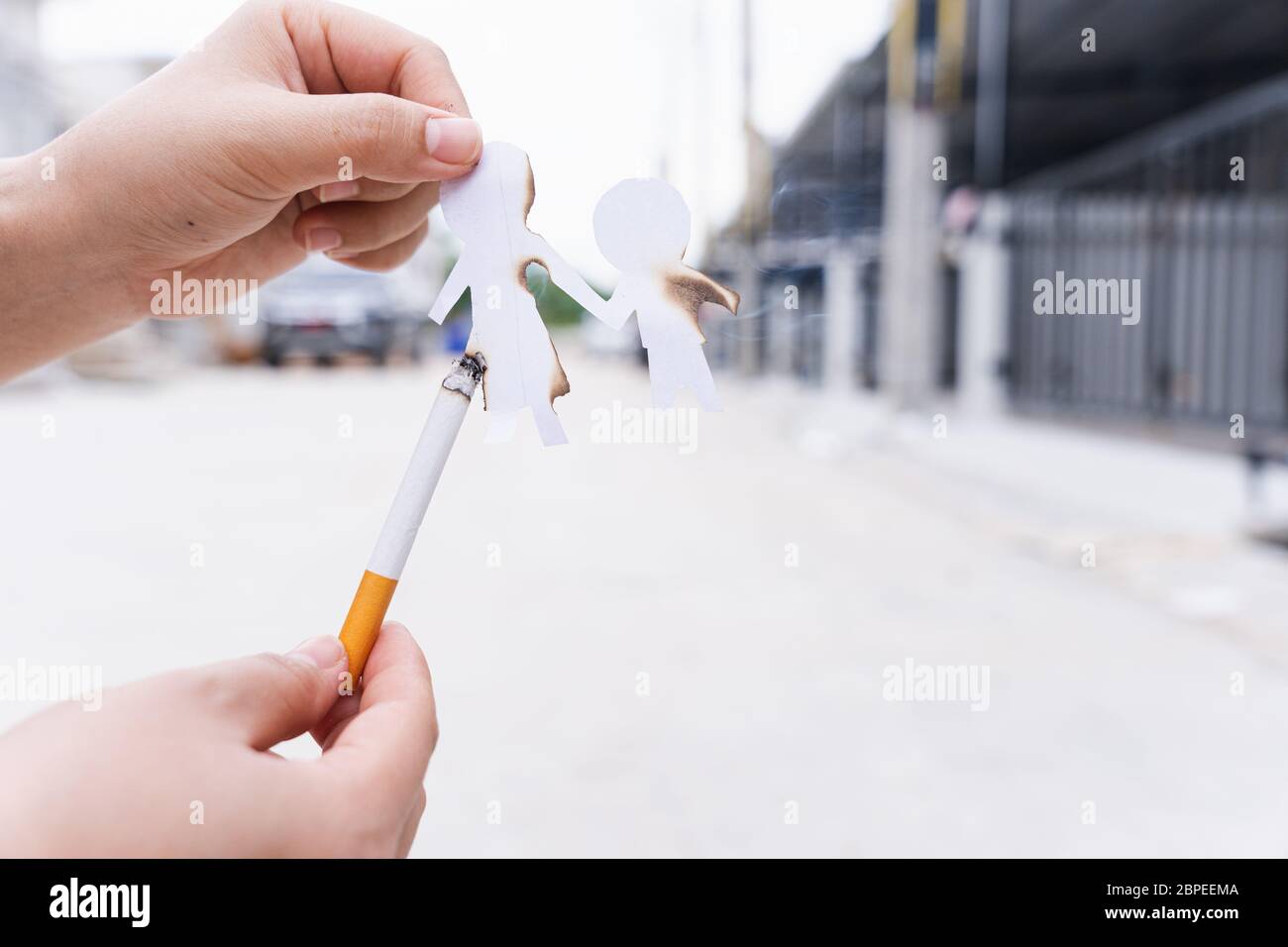 Paper cut of family members destroyed by cigarette. Smoking destroying ...