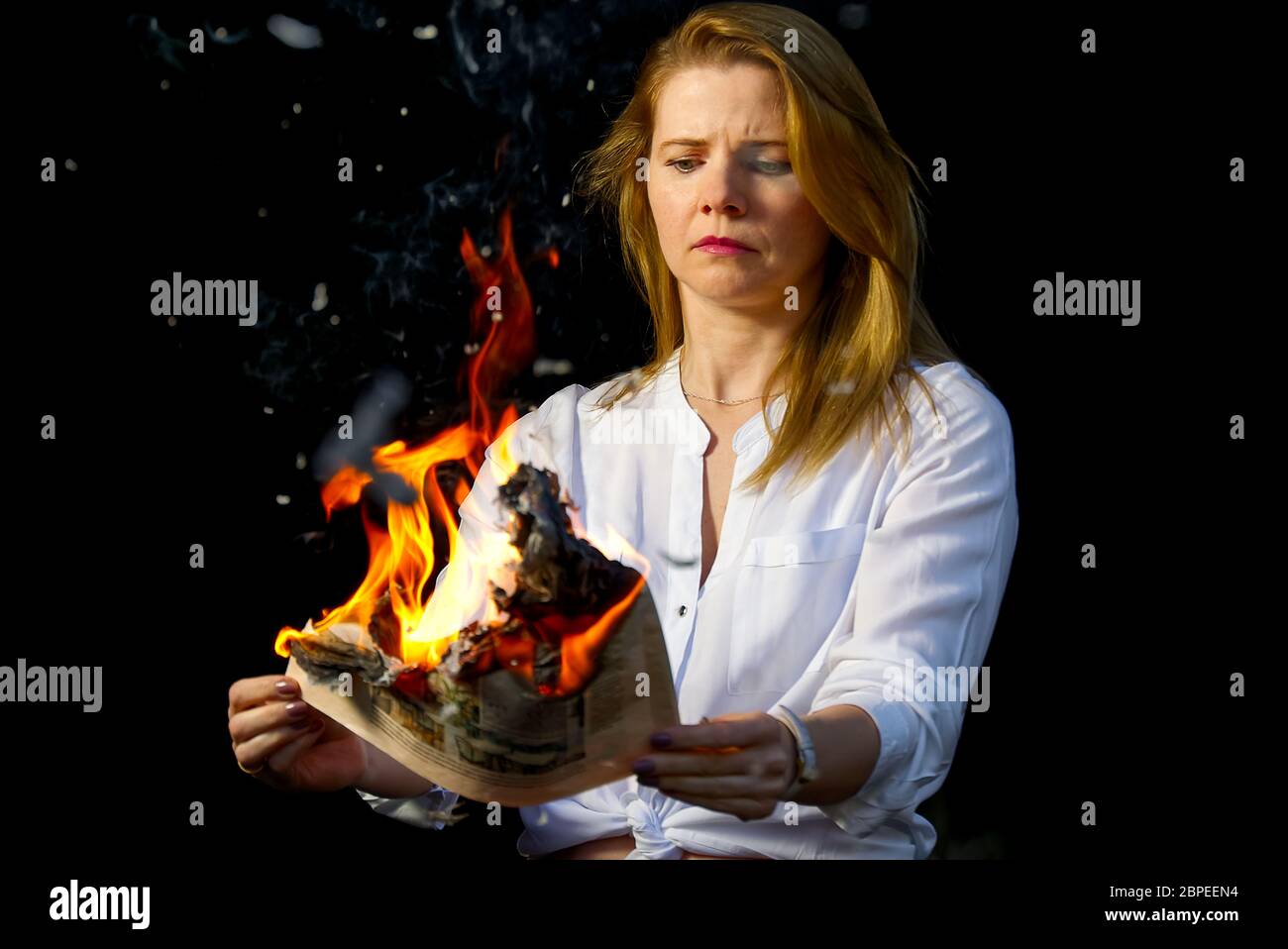 woman holding burning newspaper. Burning magazine in woman hands. fake ...