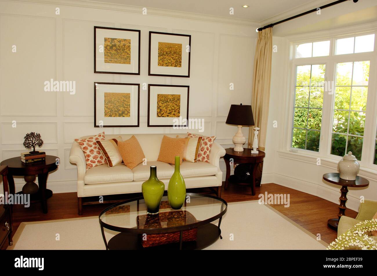 A nice living room with a large window, sofa and chairs with pictures ...