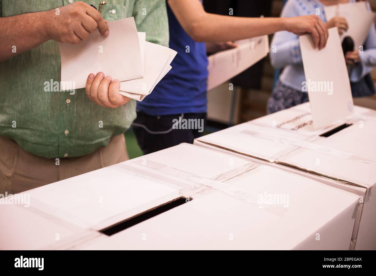 Hand of a person casting a ballot at a polling station during voting ...