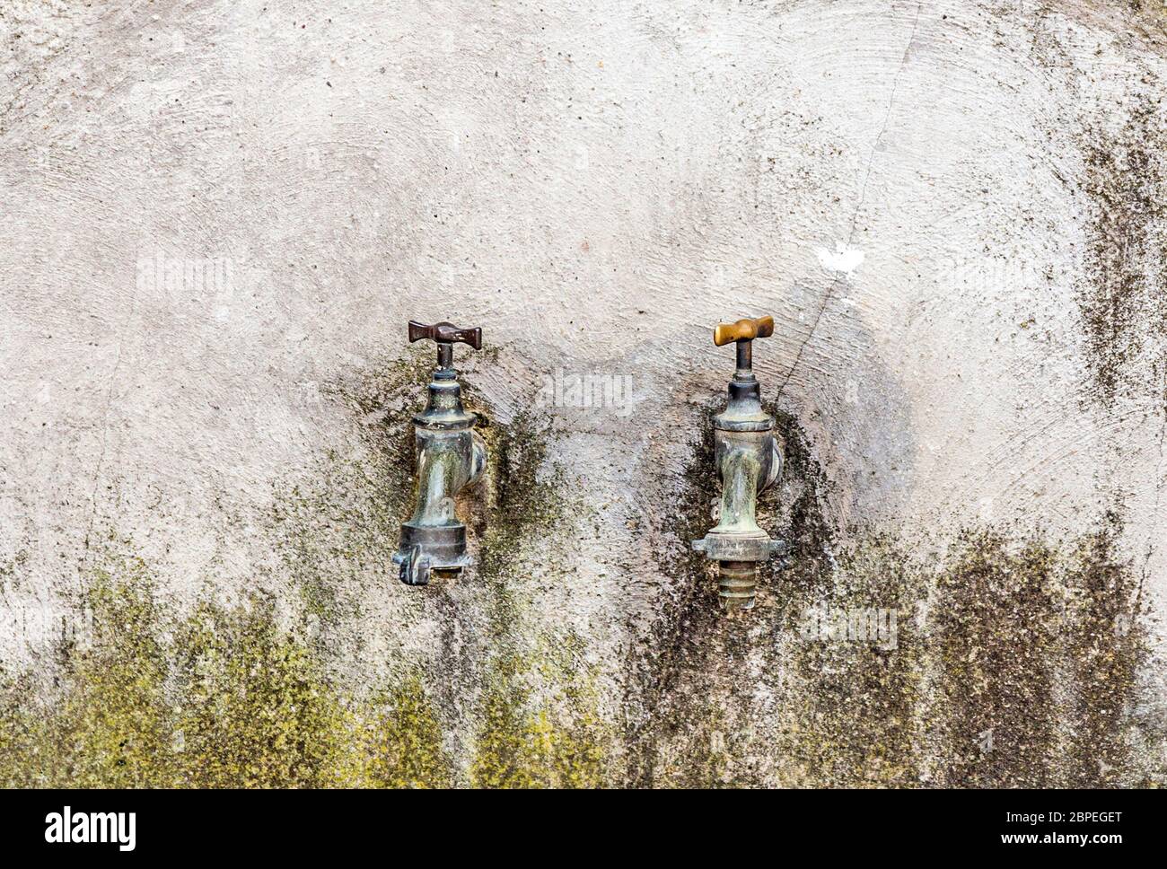 two old Water taps at a grungy outdoor wall Stock Photo - Alamy