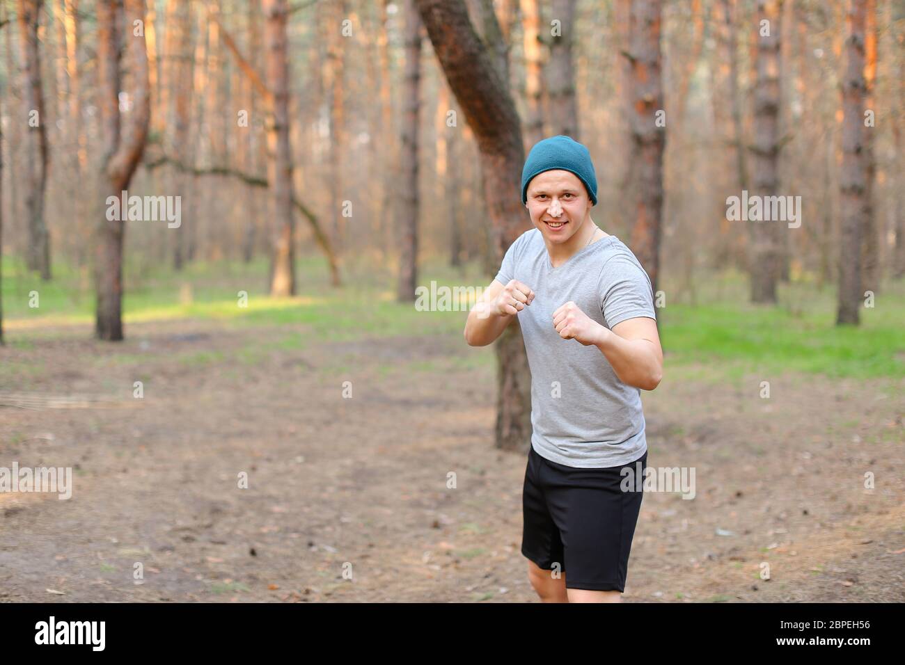 Young man doing workout and boxes exercises in morning park Stock Photo ...