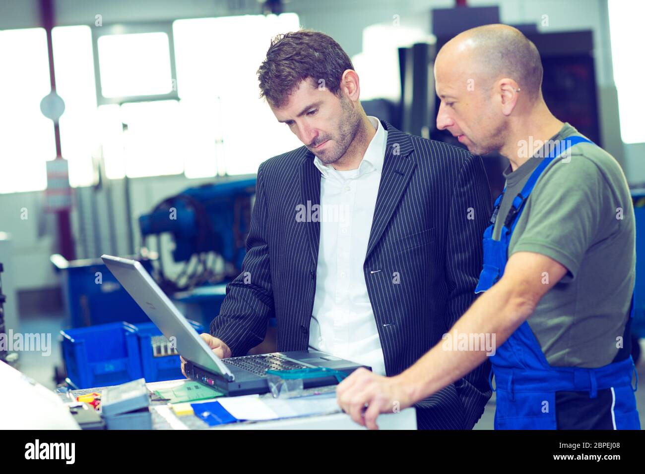 in the factory- boss and worker on work bench Stock Photo - Alamy