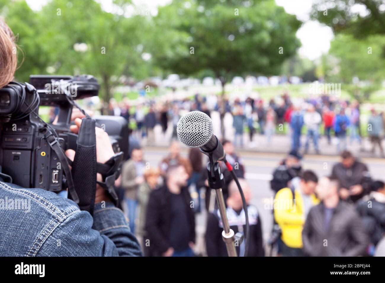 Microphone in focus, camera operator shooting blurred crowd Stock Photo ...
