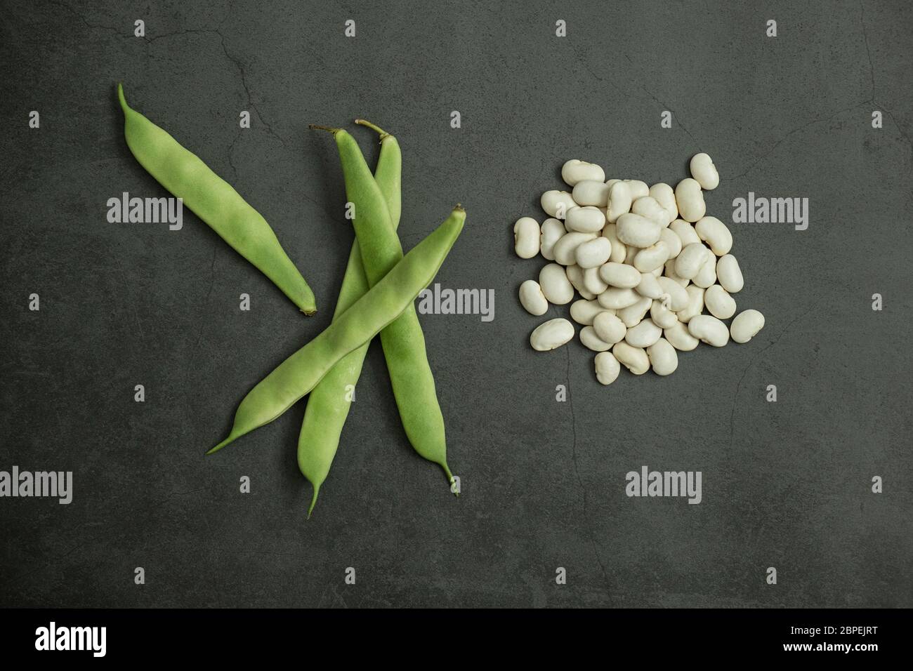 Fresh green beans and white dry beans on concrete, stone background ...
