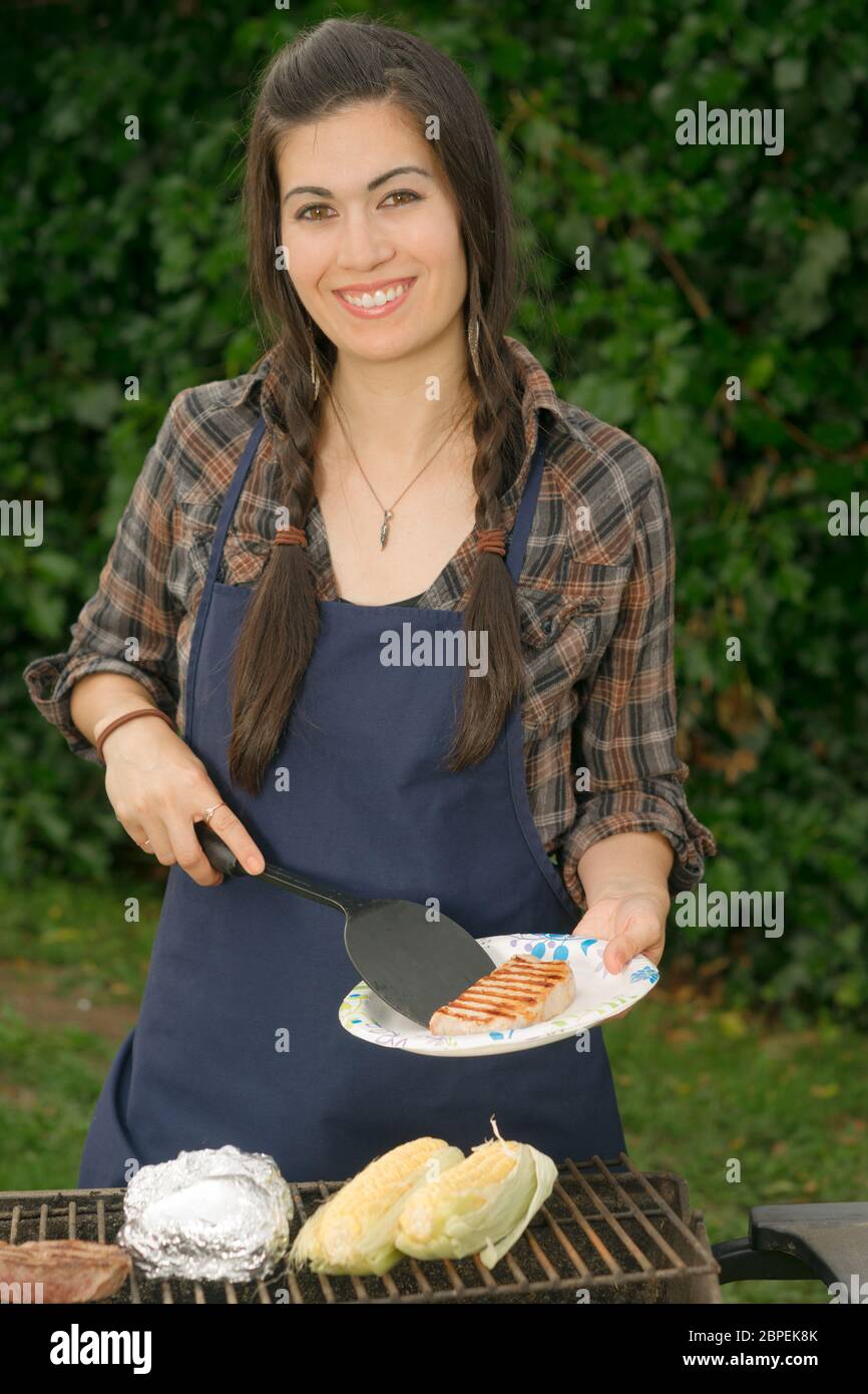 Female plates up the food at the backyard cook out Stock Photo - Alamy