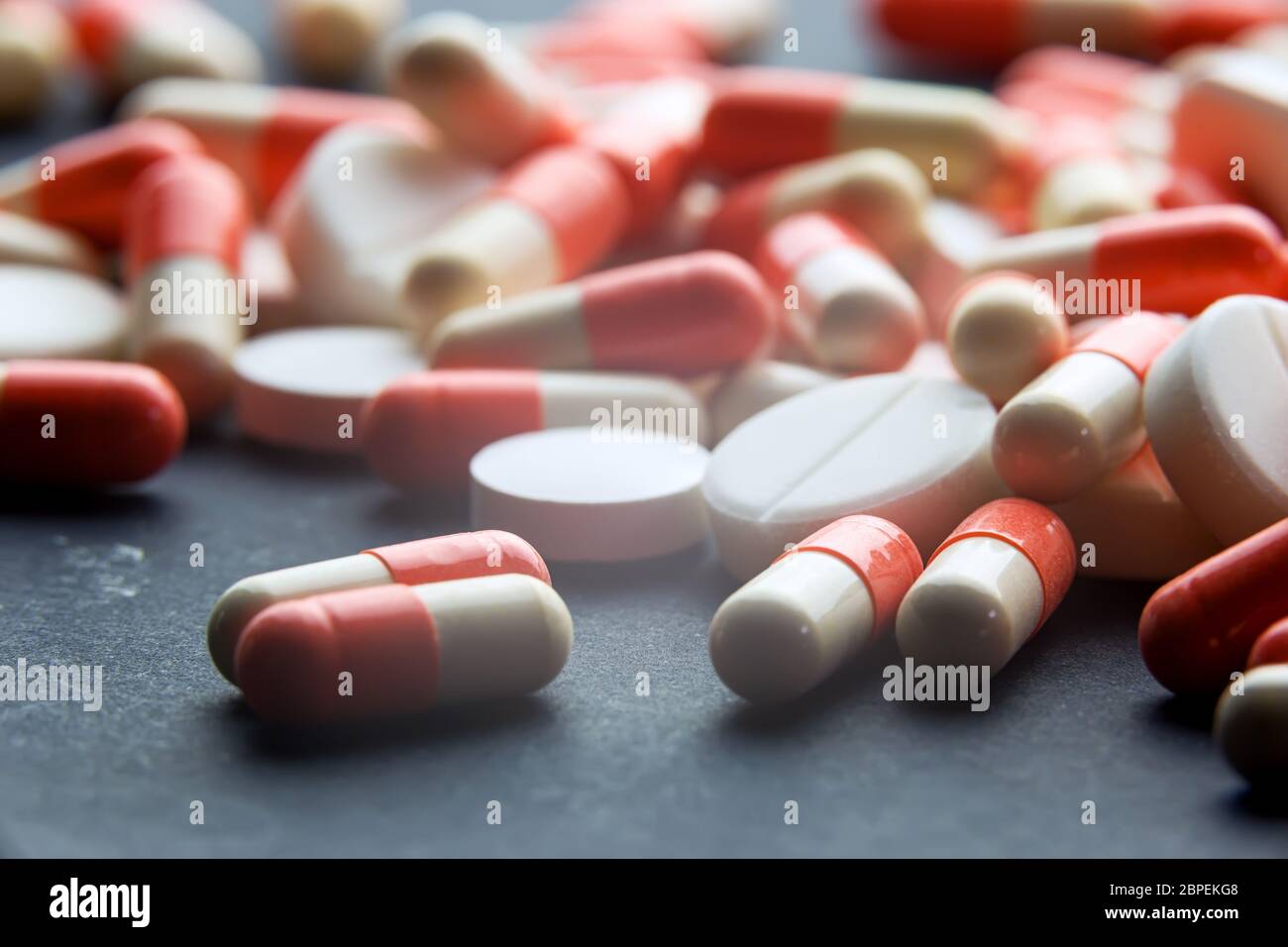 Pharmacy theme Heap of red orange white round capsule pills with ...