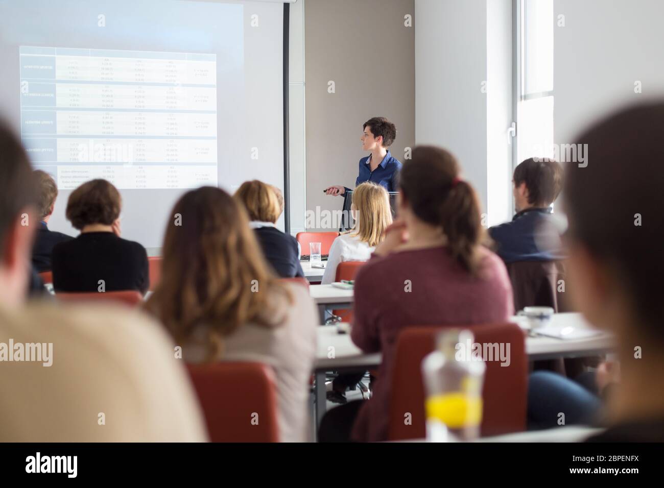 Female speaker giving presentation in lecture hall at university ...