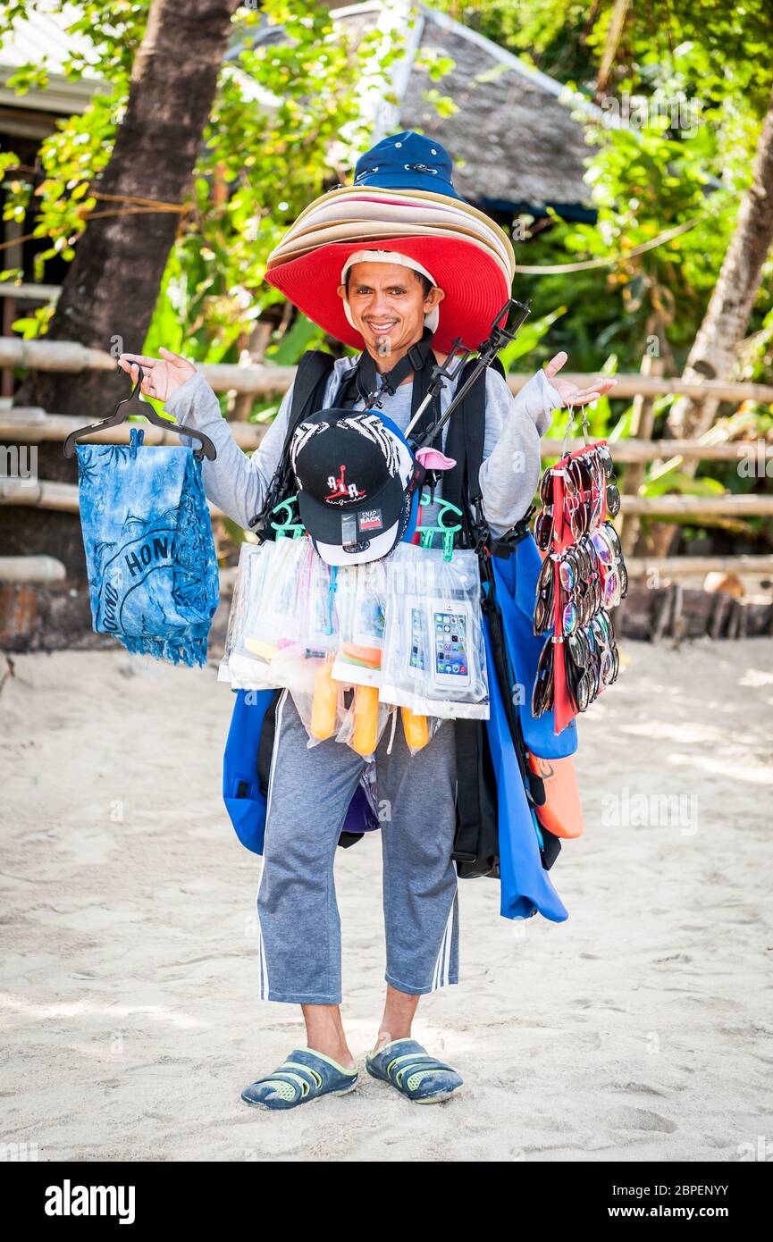 Beach vendors walk along the beach at El Nido tying to sell all manner ...