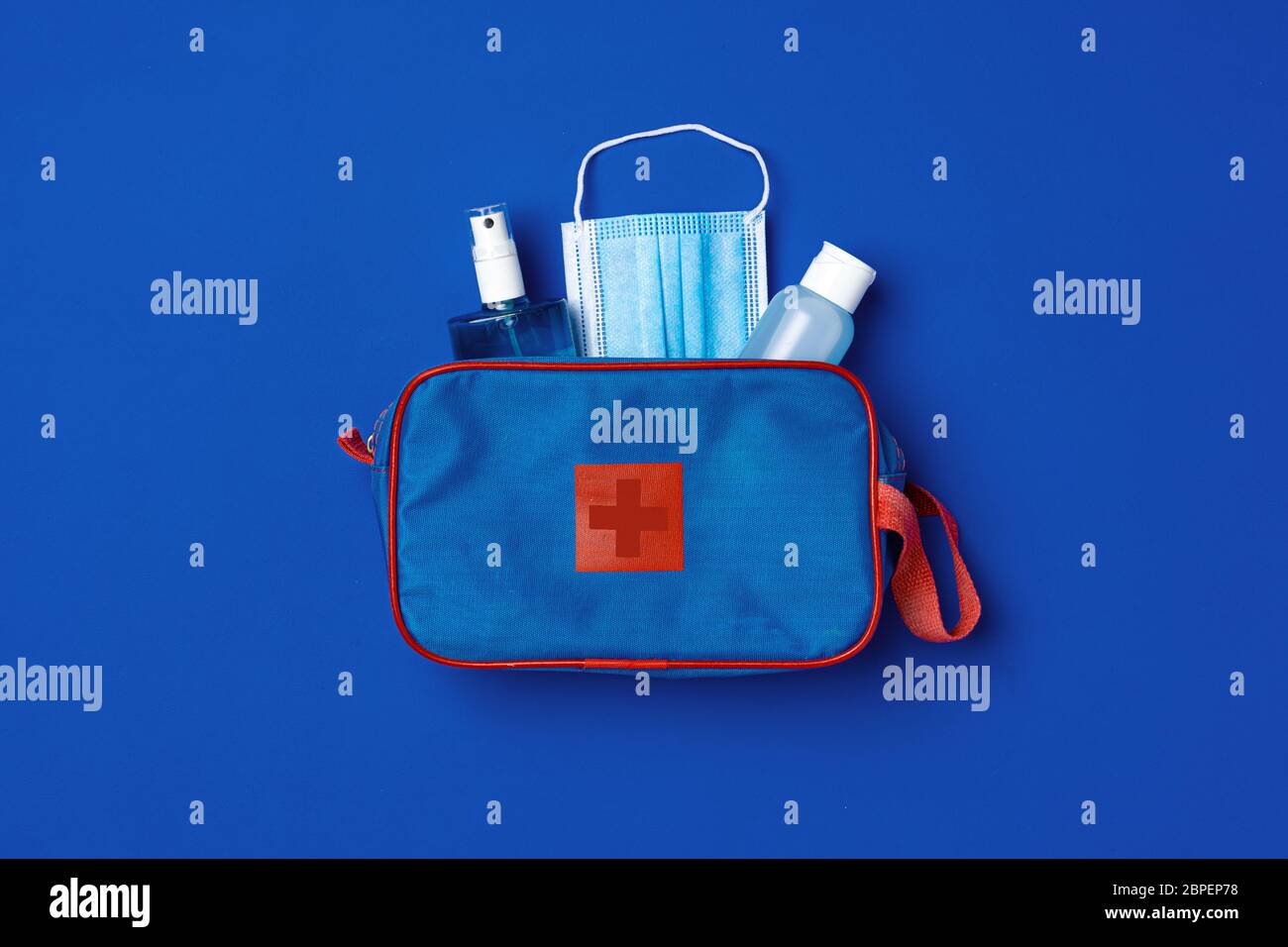 First aid kit with mask and sanitizer on blue background Stock Photo ...