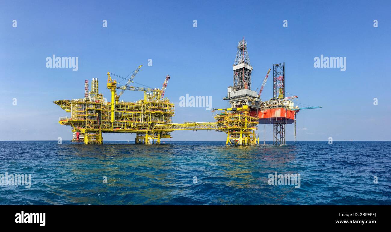 Oil and gas industries. Panorama of red jacket rig drilling on top of ...