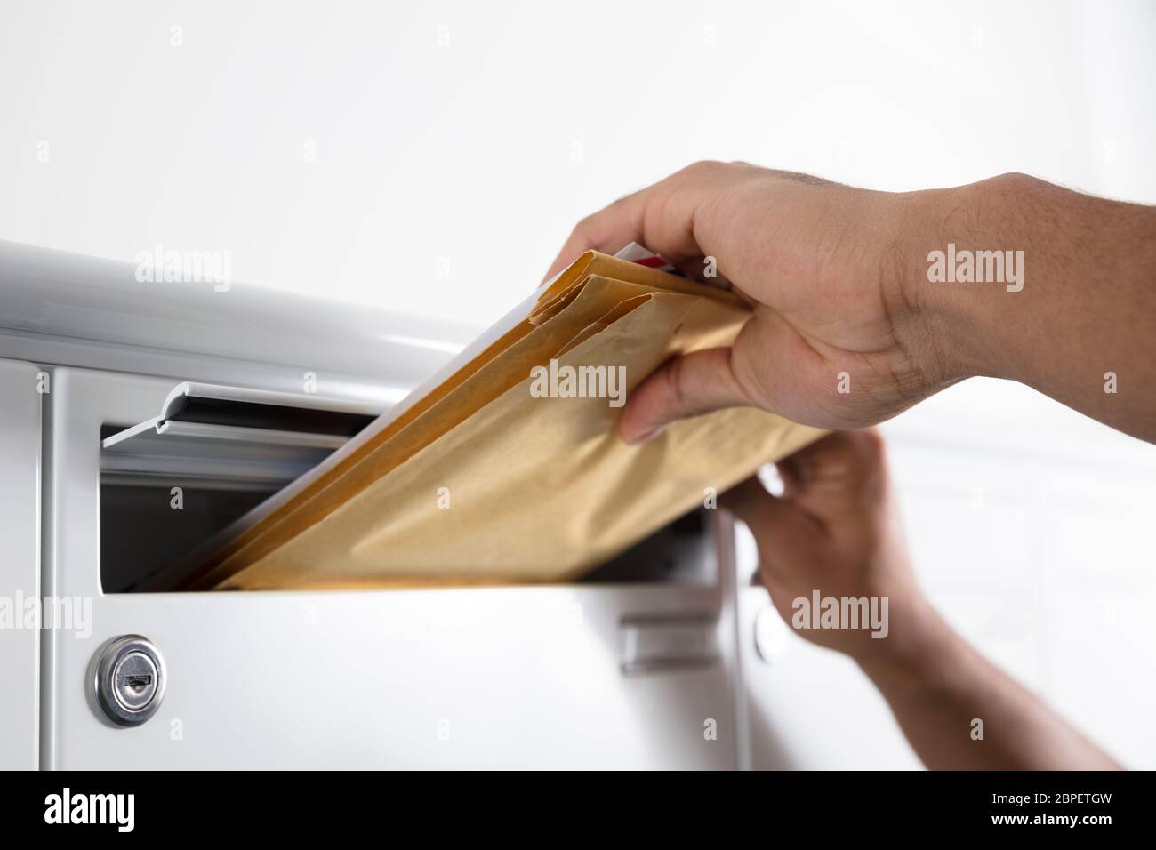 Close-up Of A Postman's Hand Putting Letters In Mailbox Stock Photo - Alamy