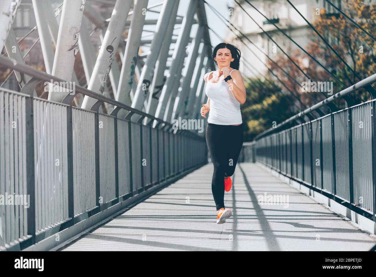 City workout. Beautiful young woman running in an urban setting Stock ...