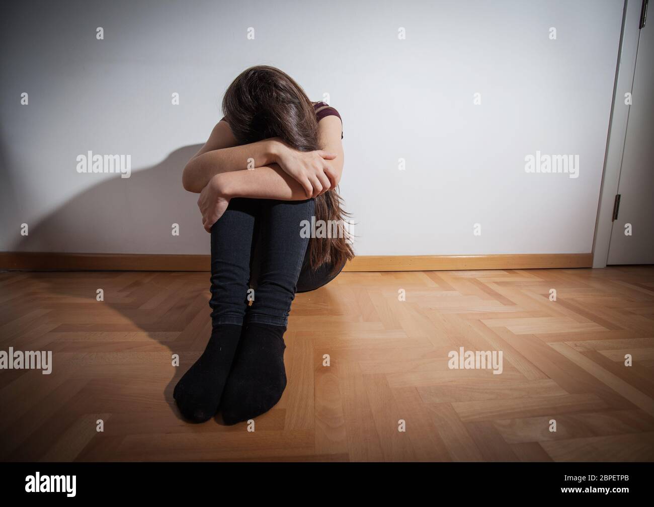 Depression teenager sitting on floor in empty room Stock Photo - Alamy